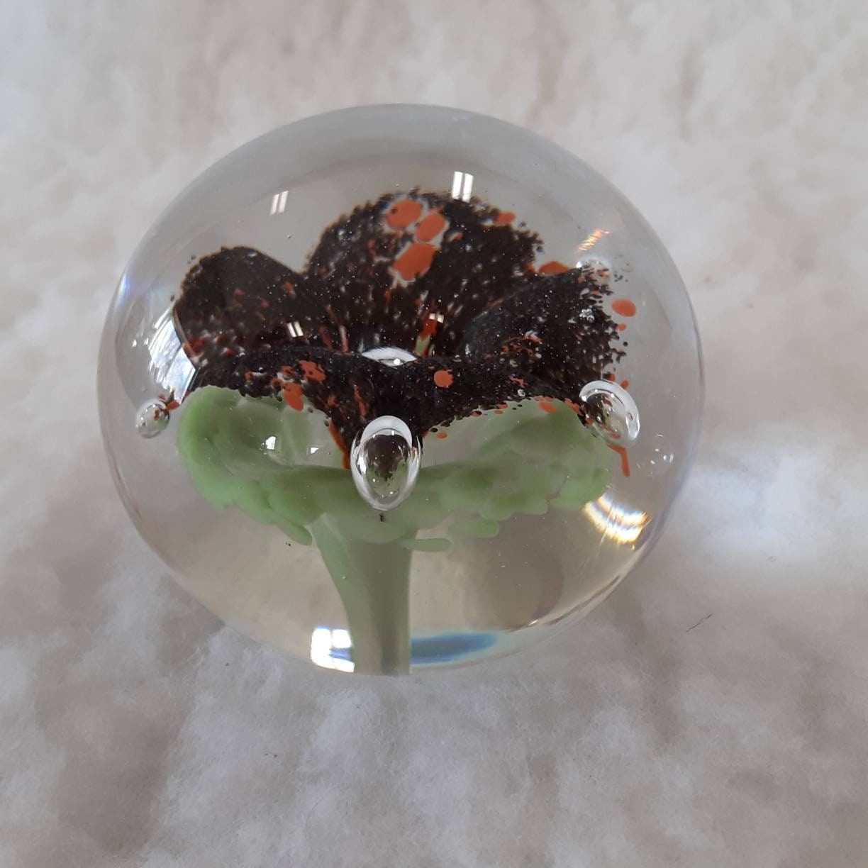 Round Glass Paperweight With Black and Orange Flower and Green Stems ...