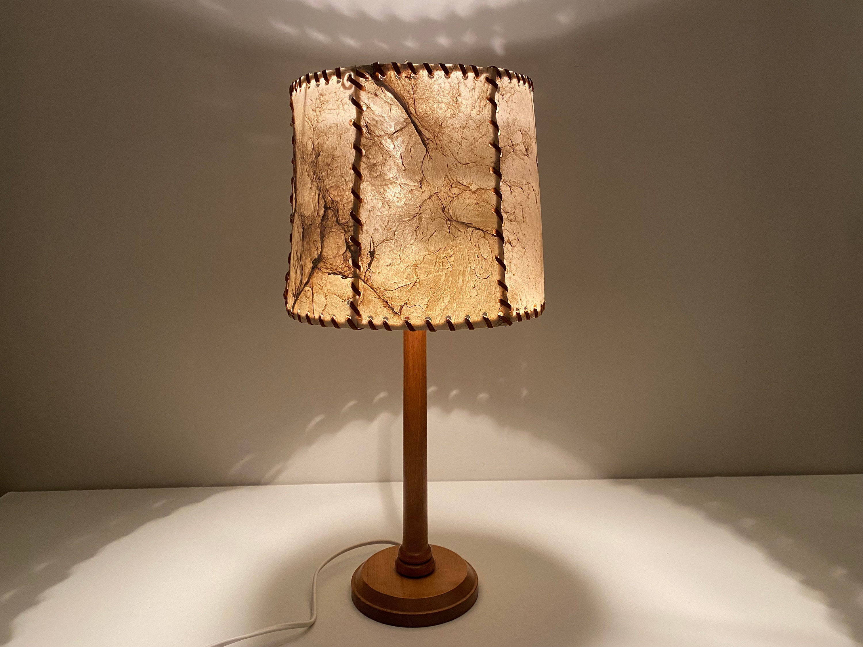A wooden table lamp base with an original laced pig skin lampshade ...