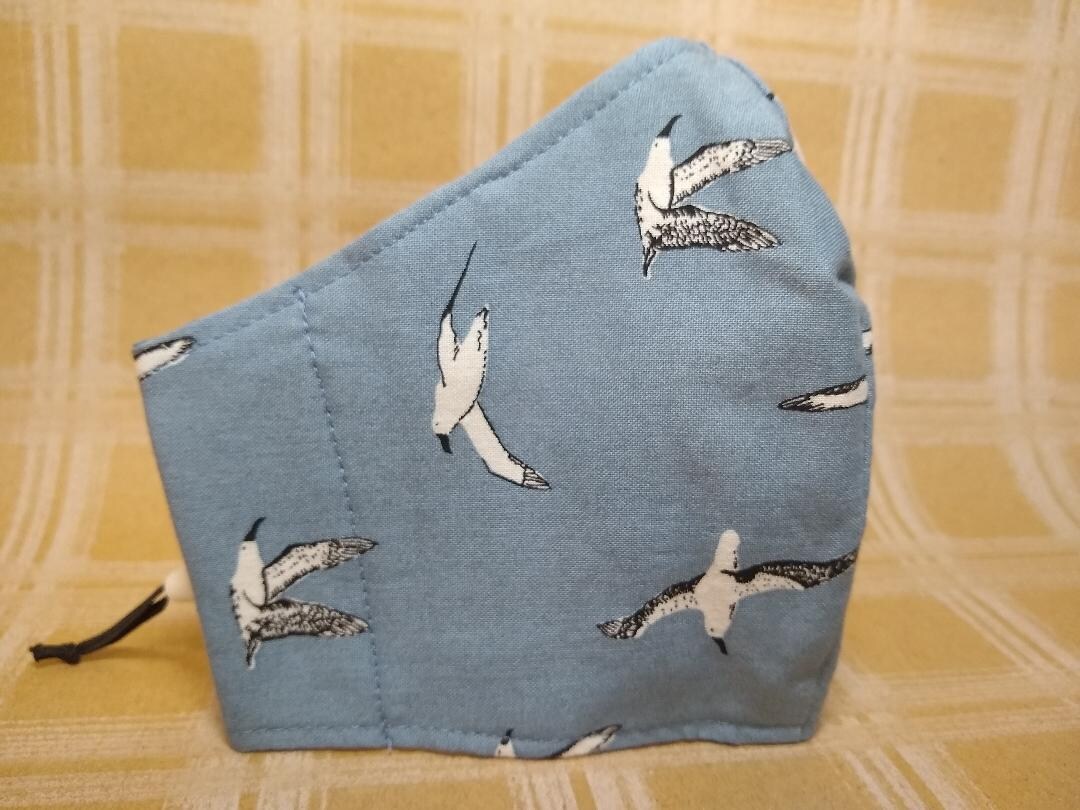 洗える100%コットン製フェイスマスク。フィルターポケット、ノーズワイヤー/ワイヤーポケット、調節可能な耳ひも付き。アルバトロス・オン・ブルー ...