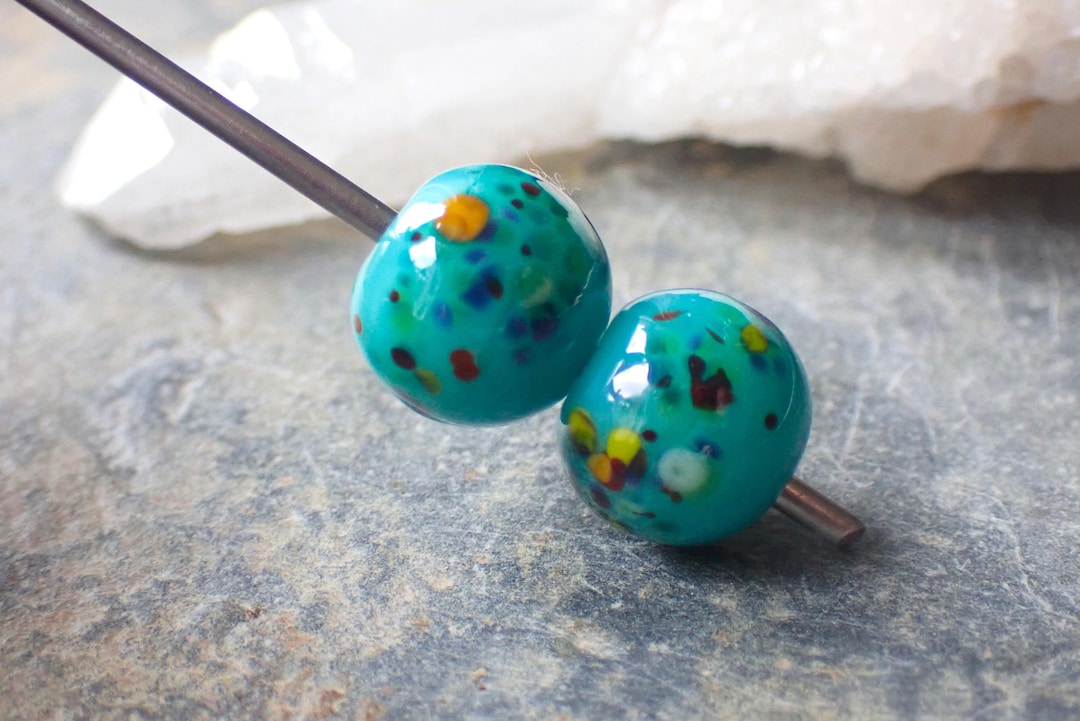 Duo De Perles En Verre Filé à La Flamme Aux éclats Floraux Sur Un Fond ...