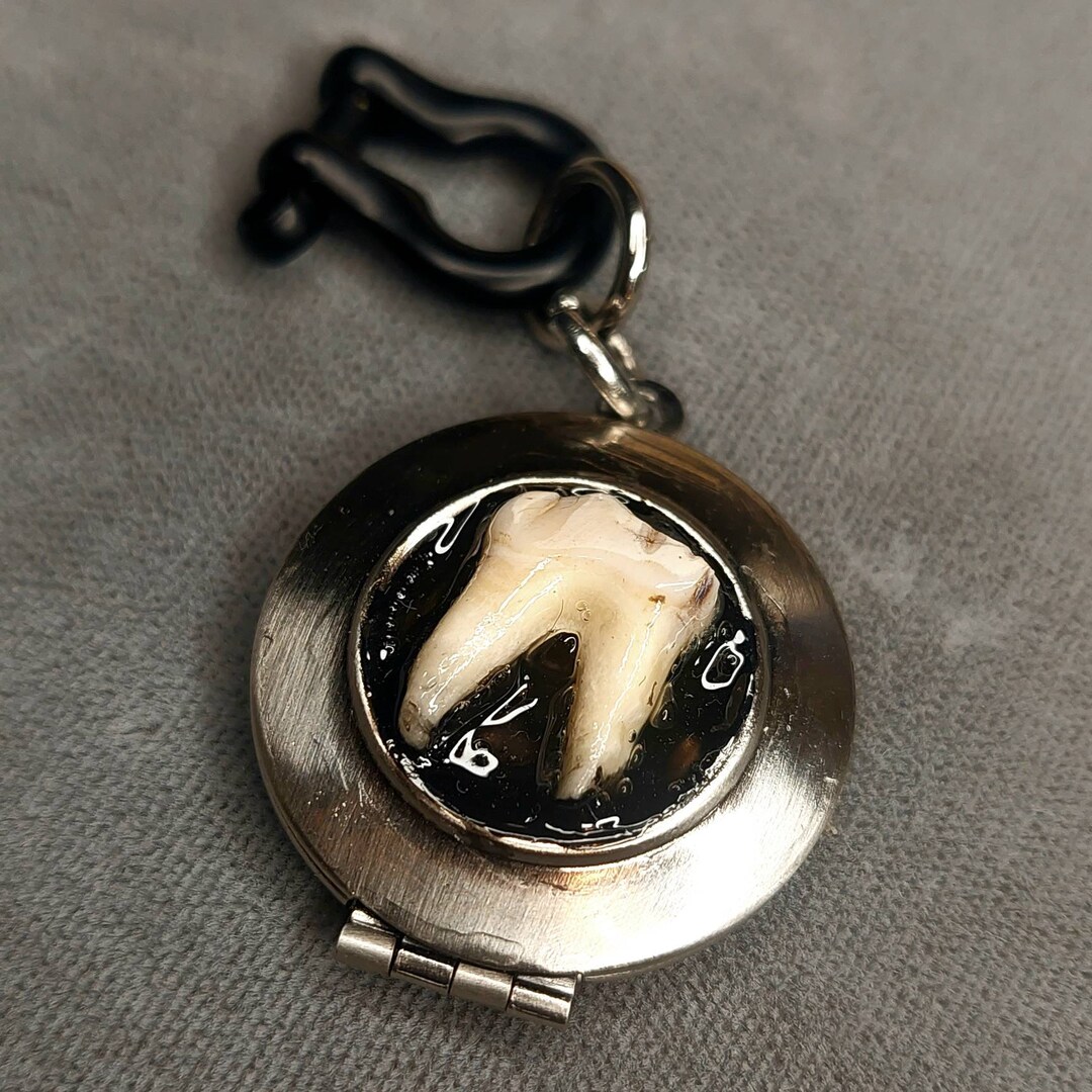 Silver Tooth Locket With Black Steel Shackle Pin. Black Backdrop With ...