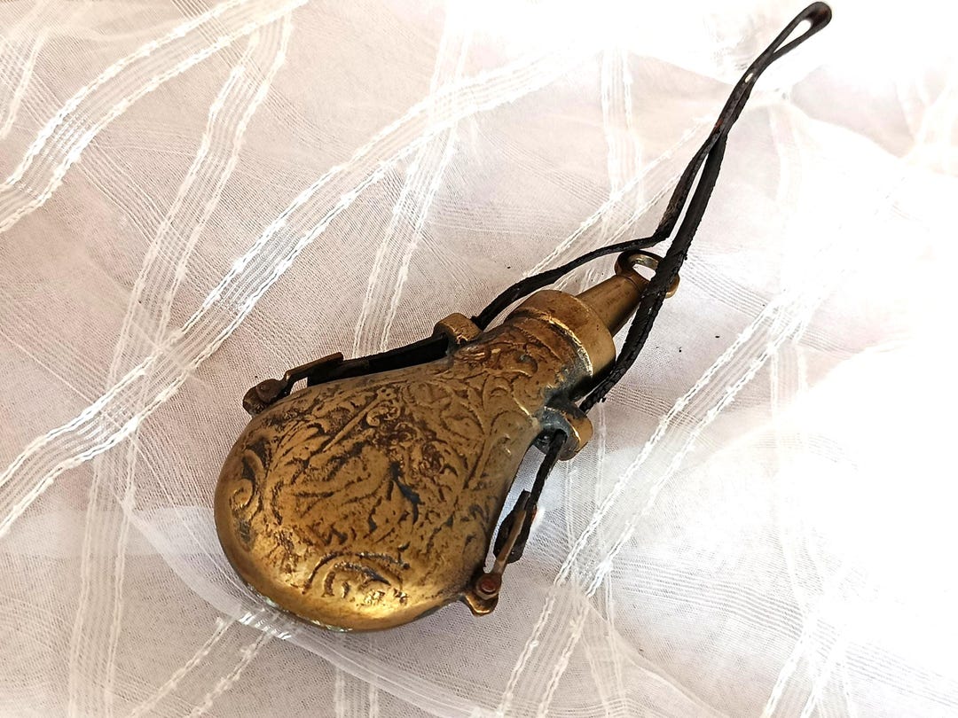 Frasco de pólvora antigo em bronze, com design ornamentado ...