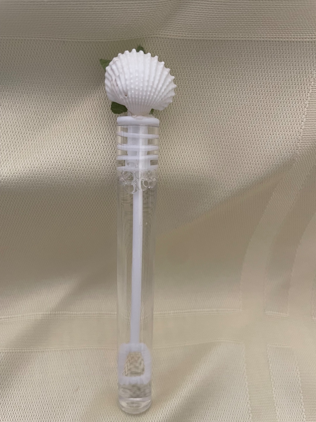Bubbles in Clear Tube Decorated With a White Shell and White Paper ...