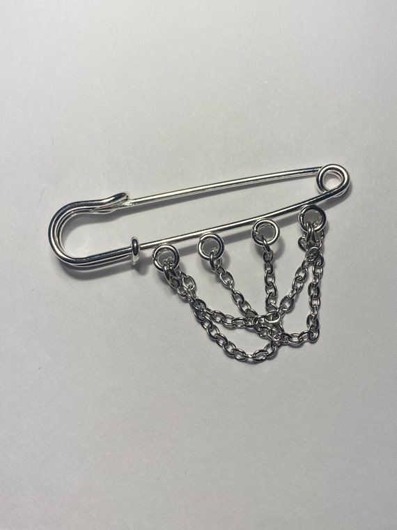 Metal brooch resembling a safety pin store