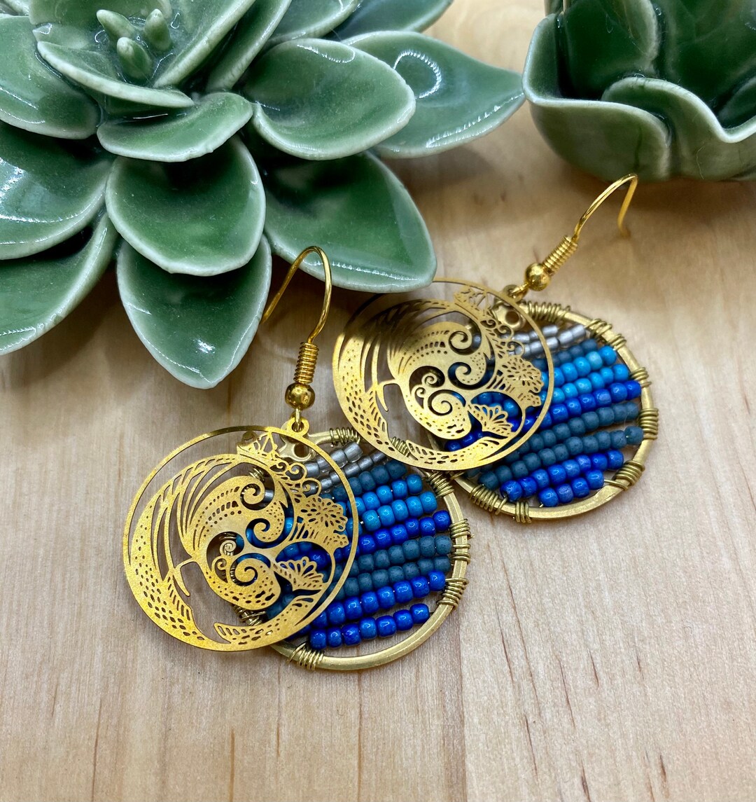 Runde goldene Ohrringe mit zartem Ornament mit Wal, und Wellen. Meer ...