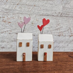 This White Wooden House Decorated With Two Pink Hearts is a Beautiful ...