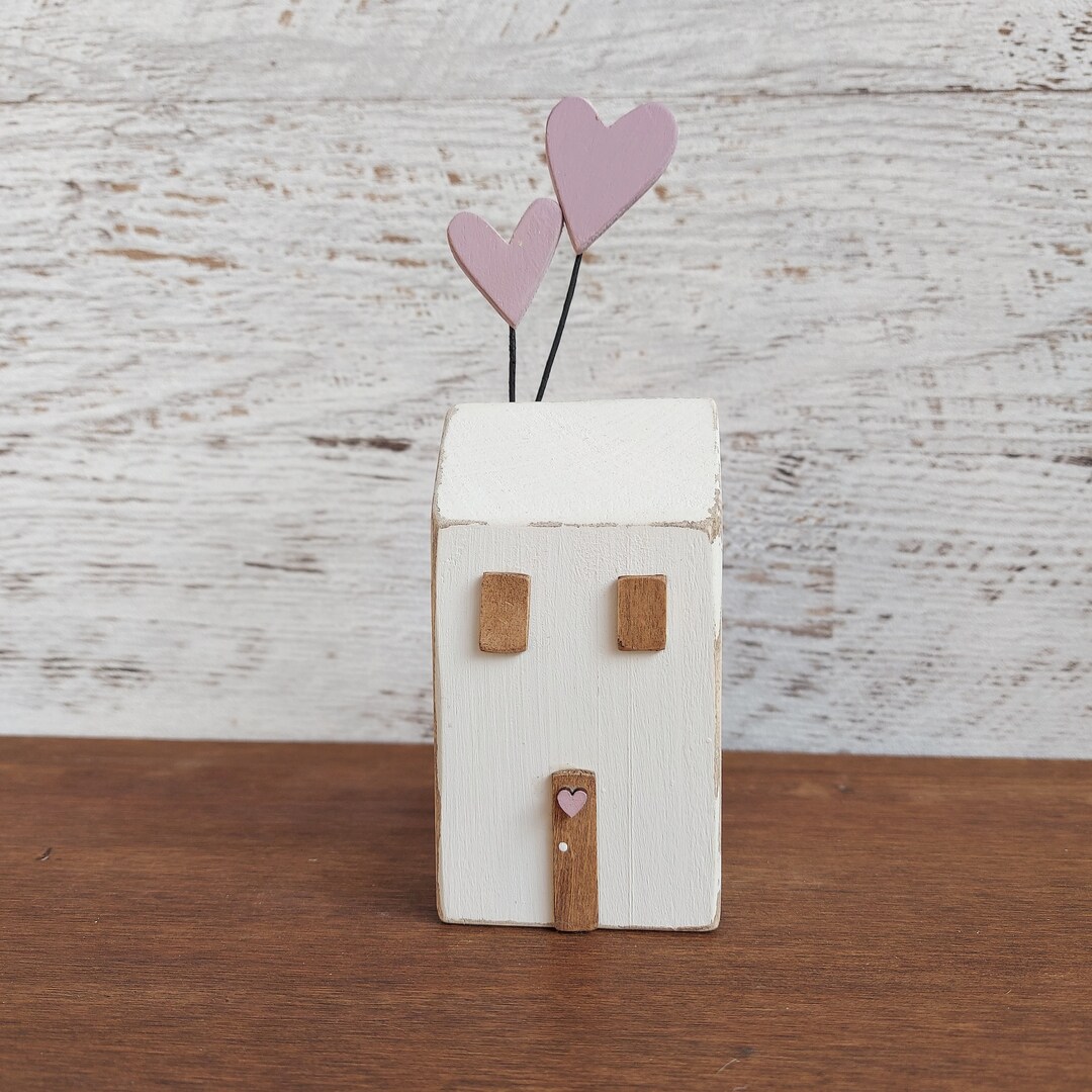 This White Wooden House Decorated With Two Pink Hearts is a Beautiful ...