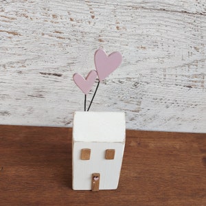 This White Wooden House Decorated With Two Pink Hearts is a Beautiful ...