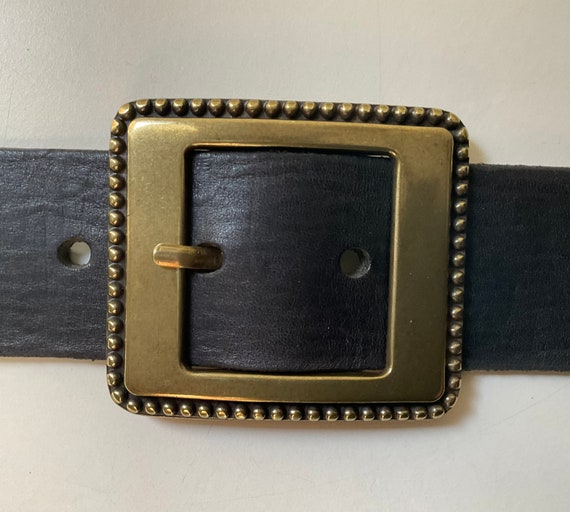 Clean,classic centre bar belt buckle with rivet borde… - Gem