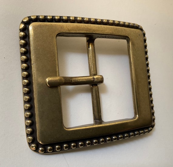Clean,classic centre bar belt buckle with rivet borde… - Gem