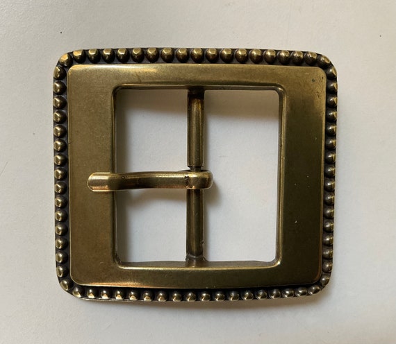 Clean,classic centre bar belt buckle with rivet borde… - Gem