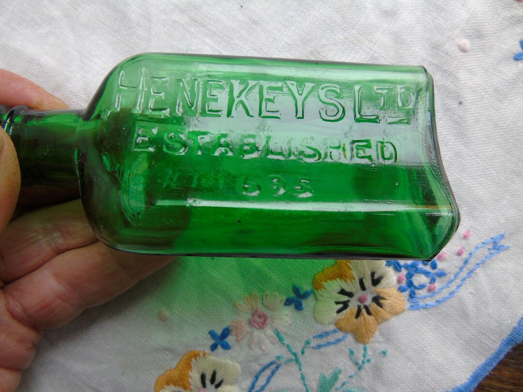 An Emerald Green Henekeys Ltd, Crescent Shaped Miniature Pocket Whiskey ...