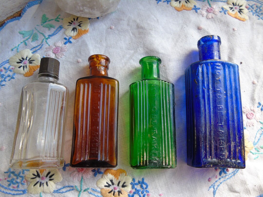 Four Poison Bottles, Different Colours Blue, Brown, Green and Clear ...