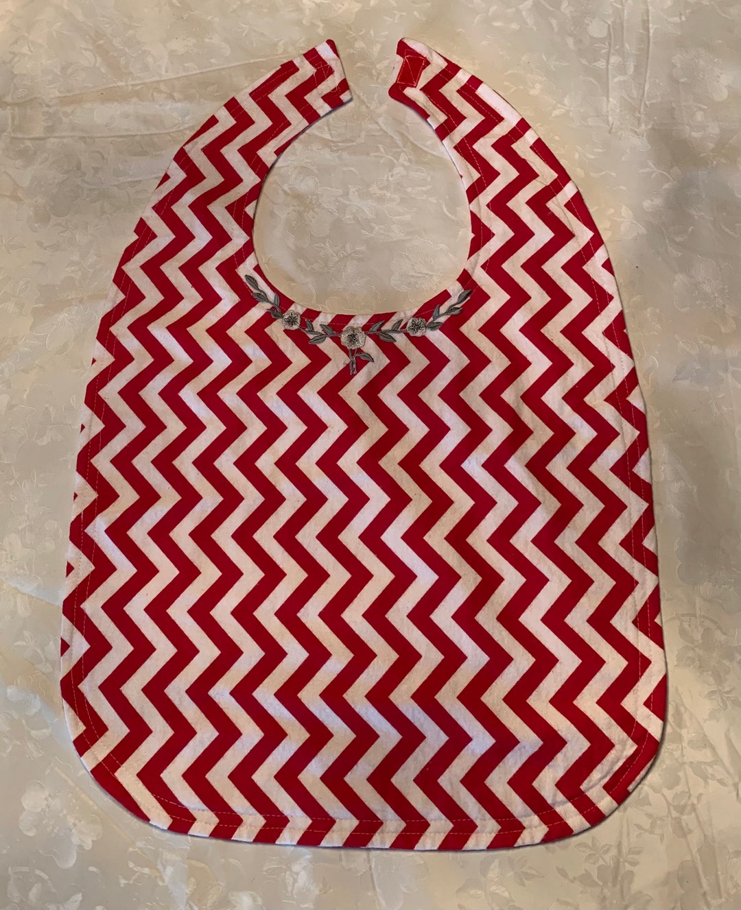 A Silver Flowers Neckline That Resembles A Necklace Adult Bibs ...