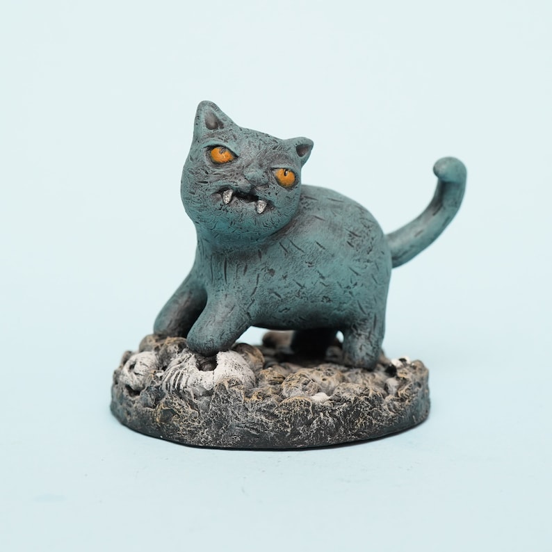 Grumpy Blue Cat Standing on Rocky Base With Skulls. Beautiful Colorful ...
