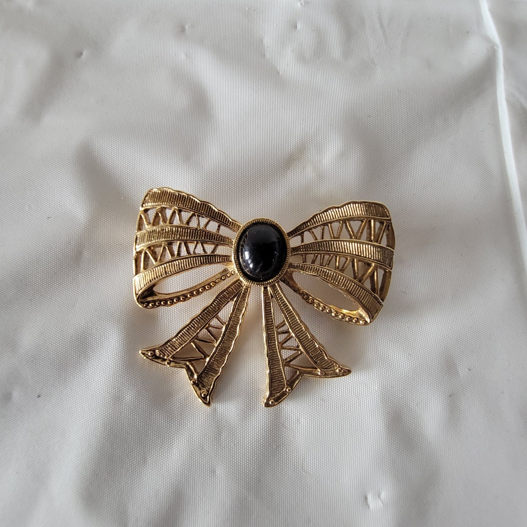 Broche noeud/ruban doré, faux ovale noir au centre, broche noeud doré ...
