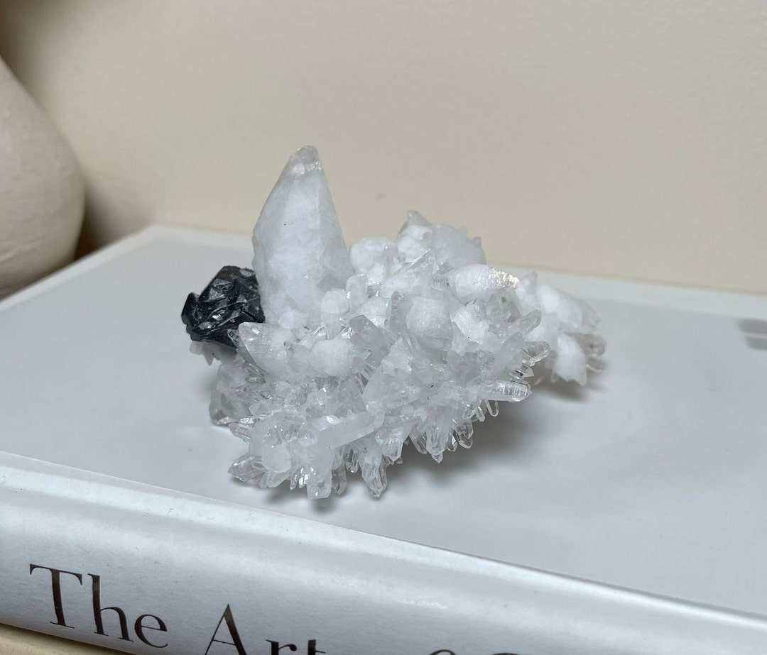 Milky Dog Tooth Calcite Point Resting on a Crystal Quartz Base, Adorned ...