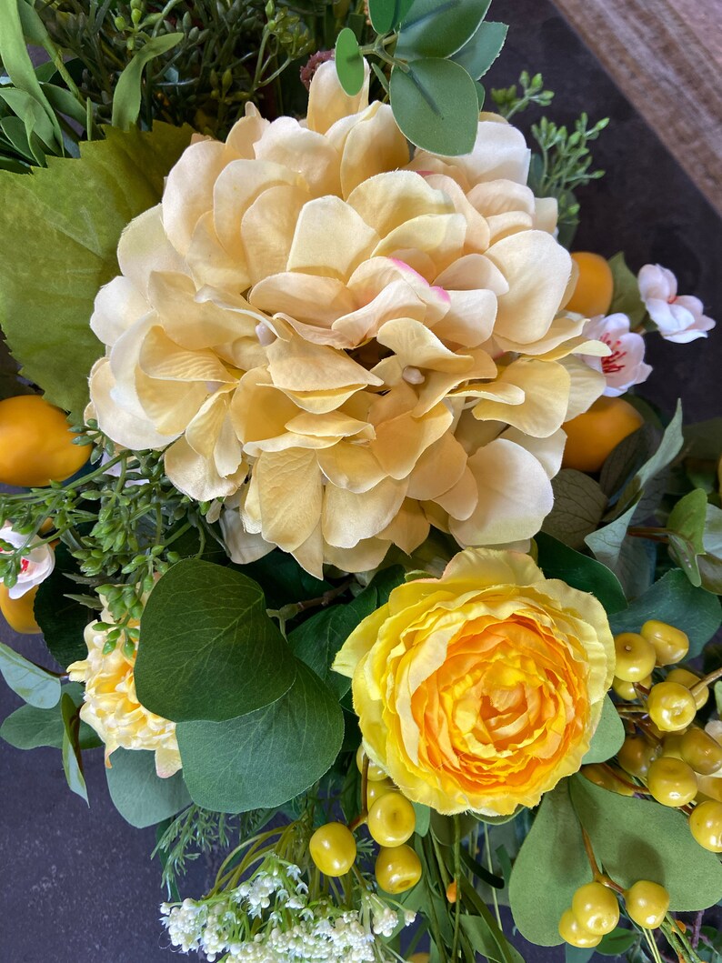 Oblong Yellow Hydrangea, Ranunculus, Lemons, and Greenery Arrangement ...