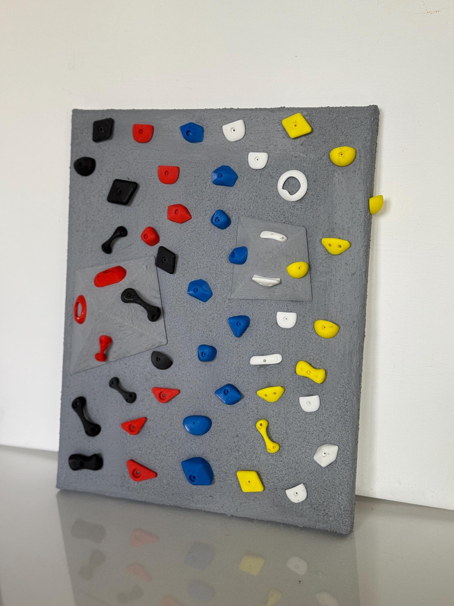 Mini Rock Climbing Wall: Rainbow Colored Rocks on a Small Climbing Wall ...
