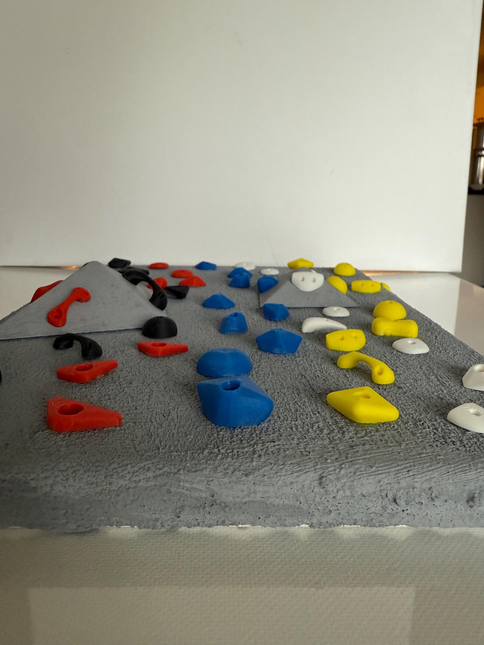 Mini Rock Climbing Wall: Rainbow Colored Rocks on a Small Climbing Wall ...