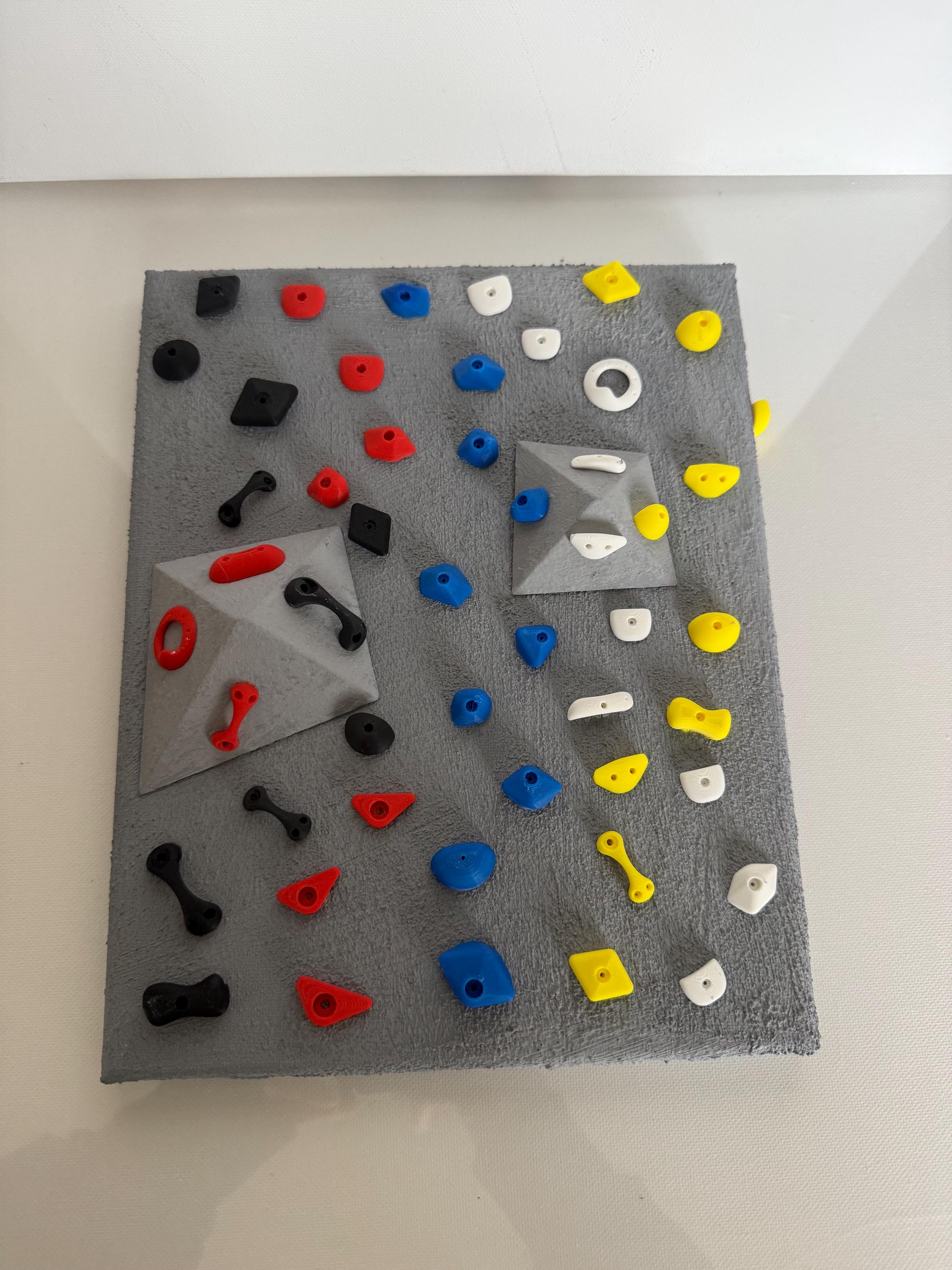 Mini Rock Climbing Wall: Rainbow Colored Rocks on a Small Climbing Wall ...