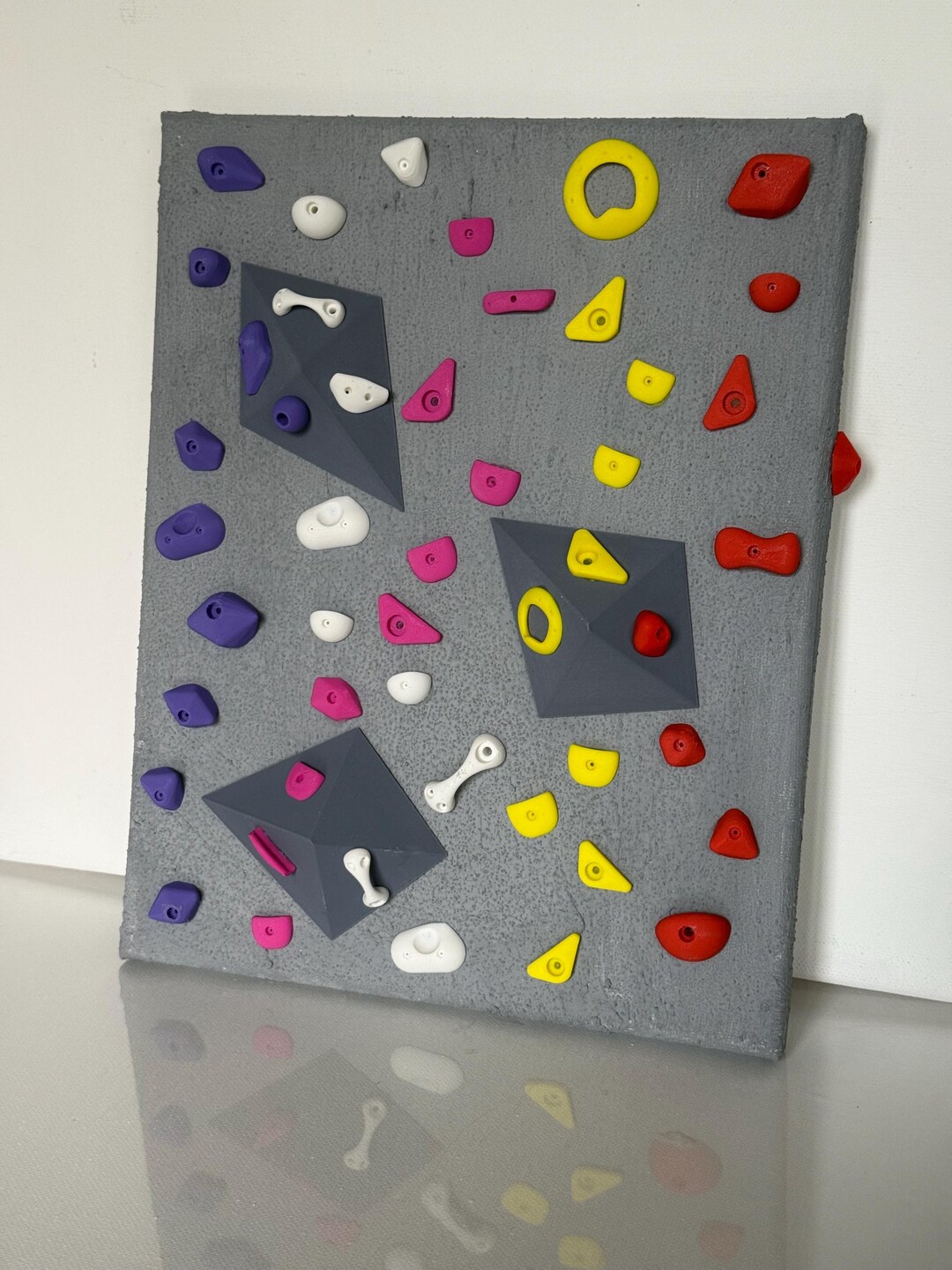 Mini Rock Climbing Wall: Rainbow Colored Rocks on a Small Climbing Wall ...