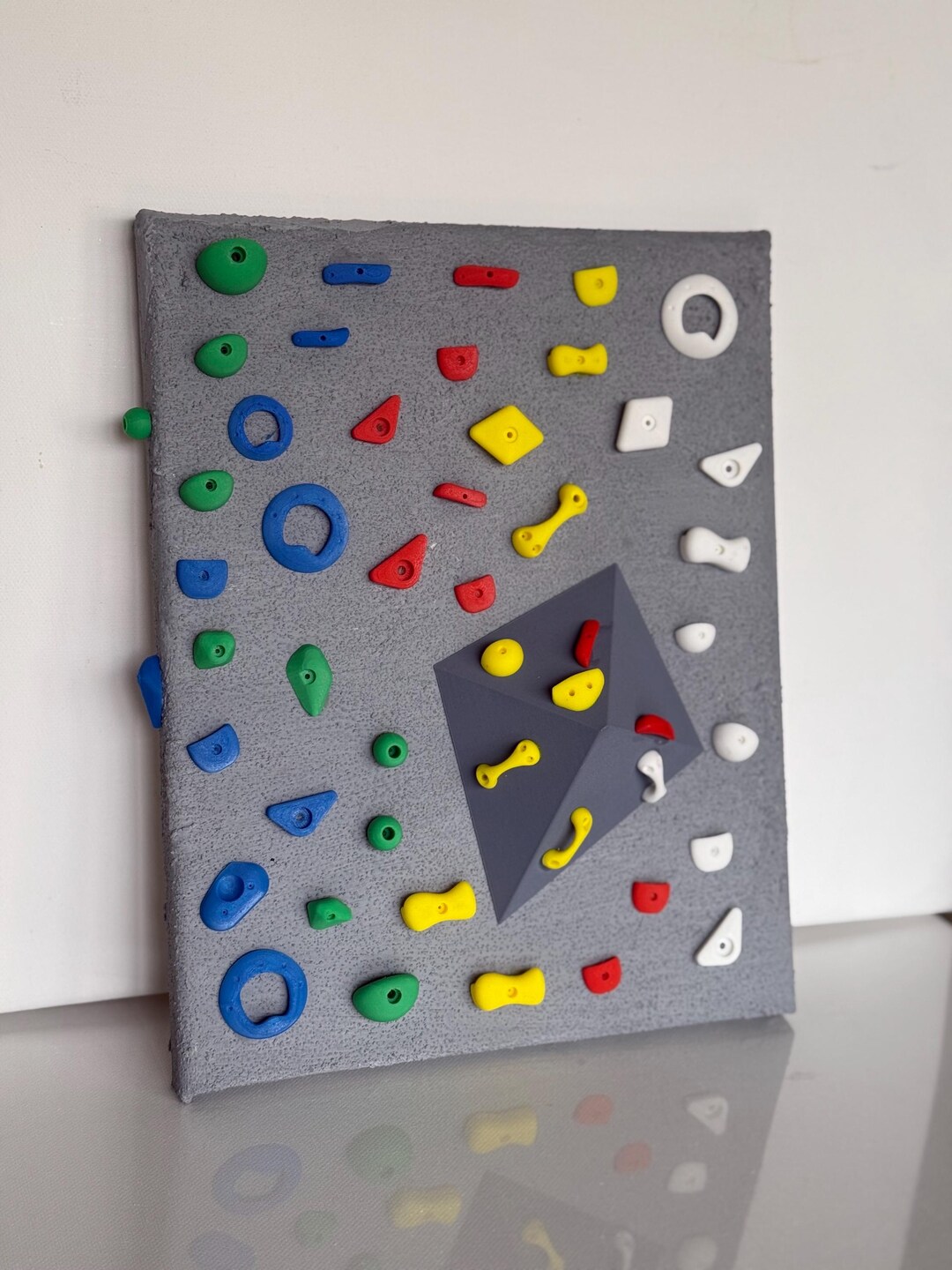 Mini Rock Climbing Wall: Rainbow Colored Rocks on a Small Climbing Wall ...