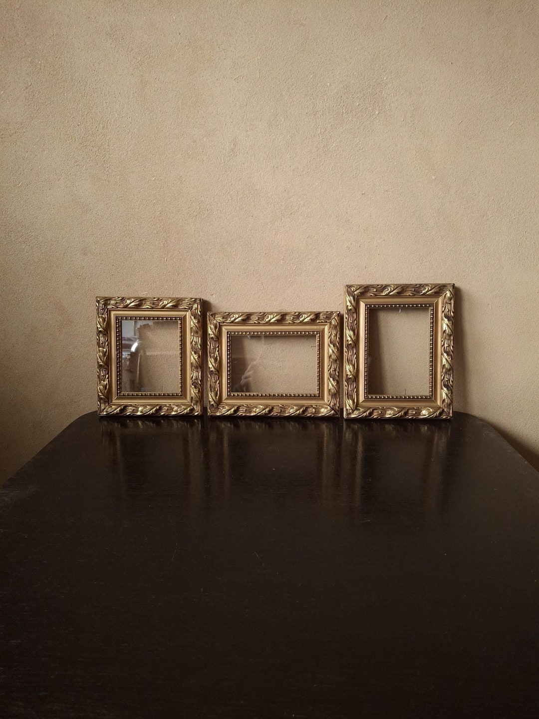 A Trio of Smaller Ornate Wooden Golden-colored Picture Frames With ...