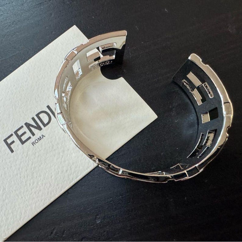 Brazalete abierto grueso en tono plateado con logotipo recortado FF de ...