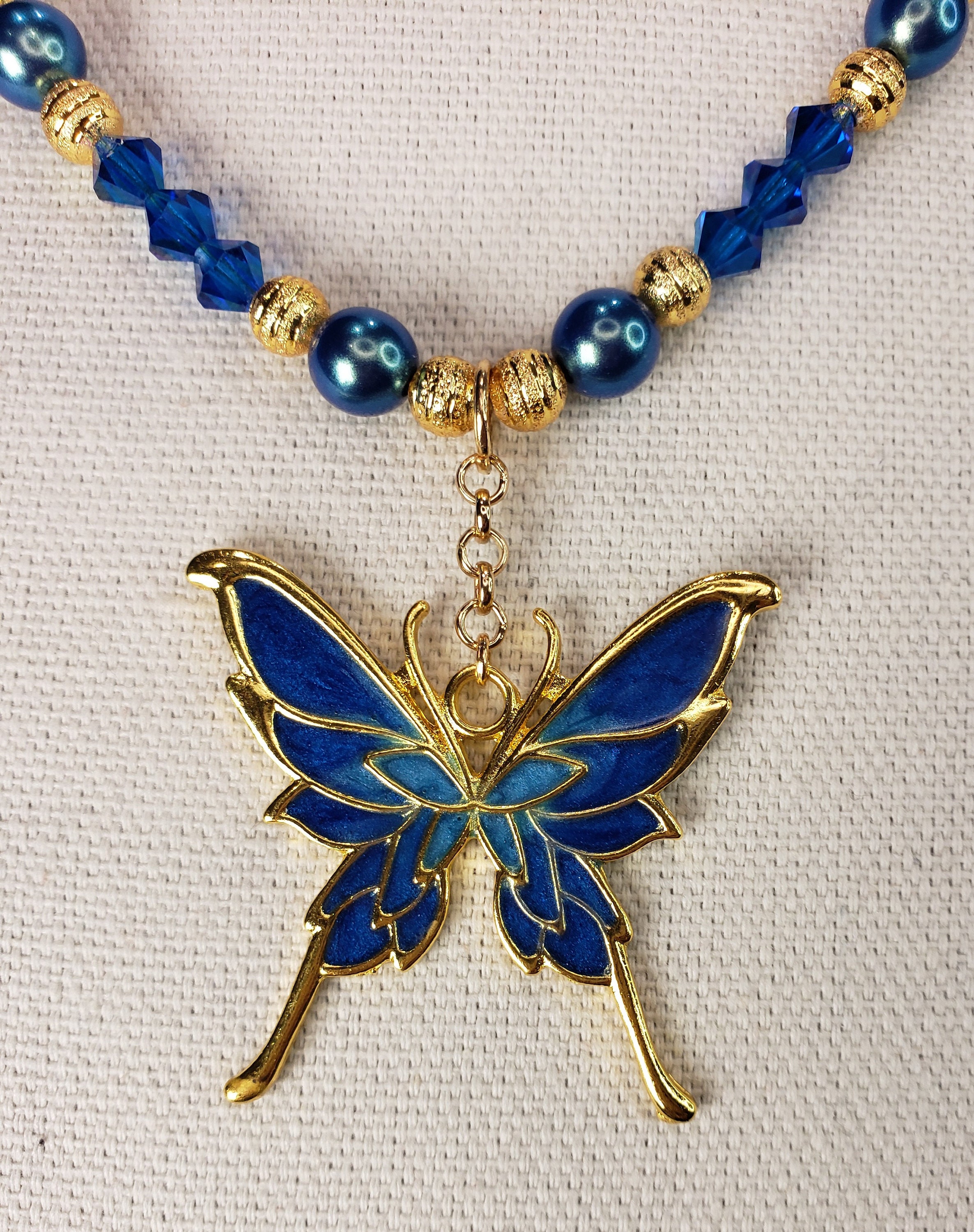 Elegant Blue and Gold Butterfly Pendant Flutters Below the Blue Beads ...
