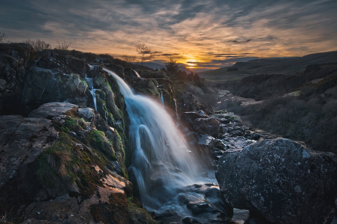 Mini Waterfall in a Country Setting With Sunset and Cloudy Skies ...