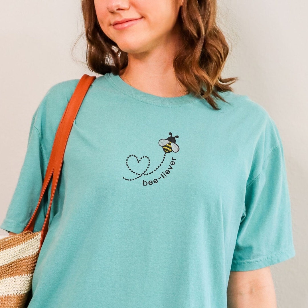 Bee-liever Camiseta cristiana bordada Ropa para mujer, camiseta cristiana de abejorro Merch ...
