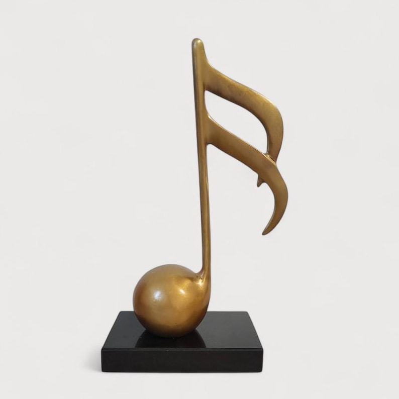 Escultura de nota musical em bronze com acabamento dourado e base de ...