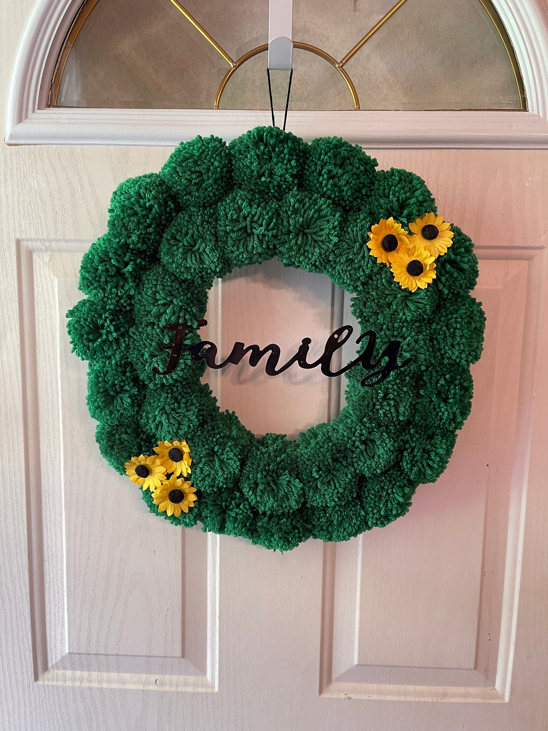 The Word Family is in the Middle of This Homemade Pompom Wreath Its ...