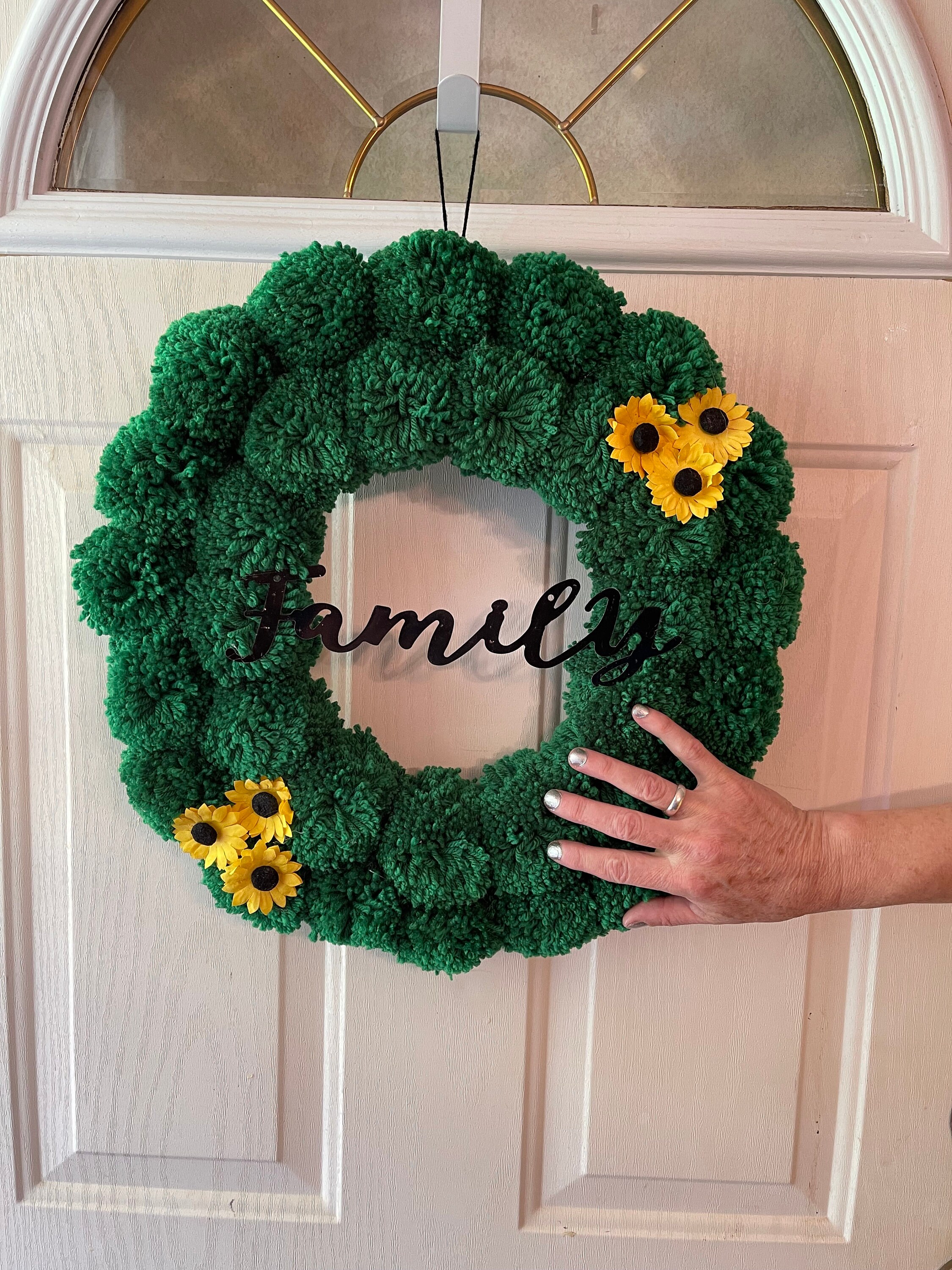 The Word Family is in the Middle of This Homemade Pompom Wreath Its ...