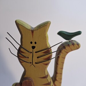 Wooden Olive Green Tabby Cat With Brown Stripes. Black Crow on His ...