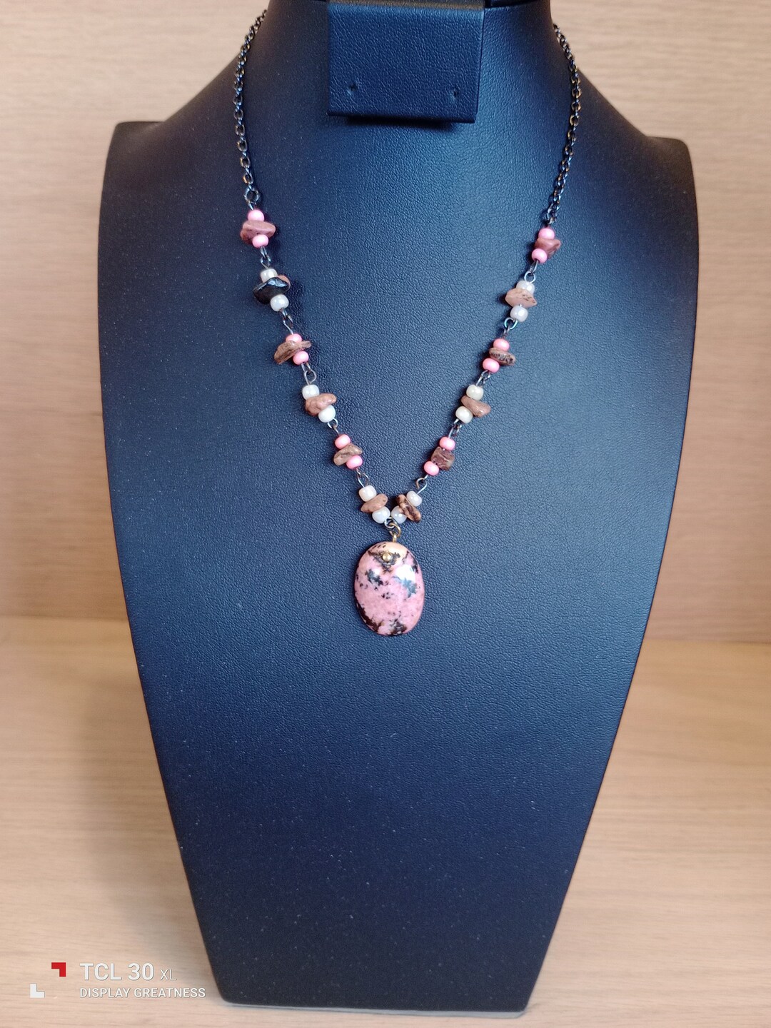 An Oval Shaped Black and Pink Granite Pendant With Multi-colored Stone ...