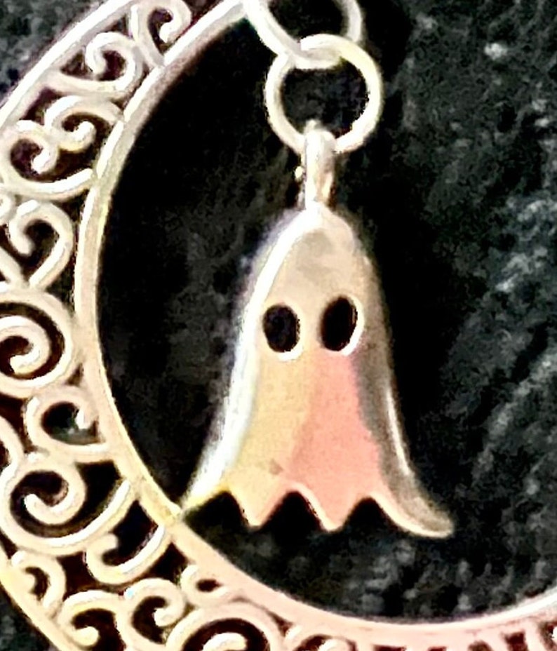 Paranormal Jewelry of A Ghost Charm Hanging Inside a Filigree Crescent ...