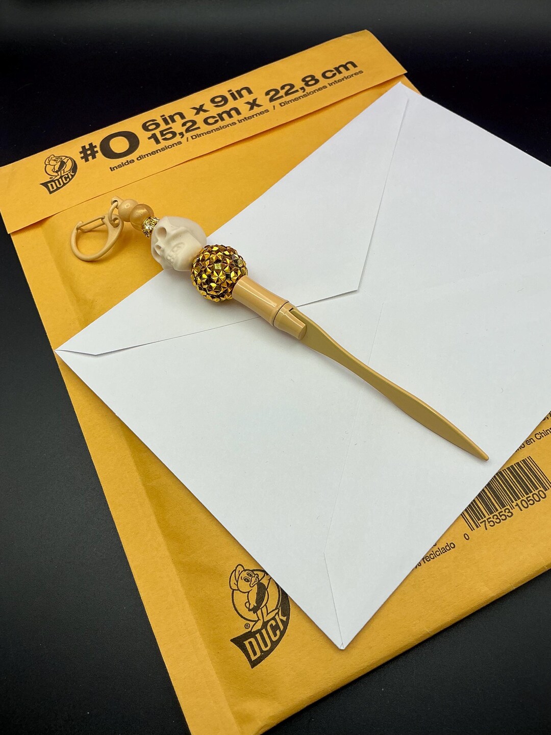 Tan Letter Opener With off White Silicone Skull. Tiny Gold Silicone ...