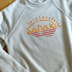 Sodak Neon Sun Crew Sweatshirt by Oh Geez! Design - South Dakota ...