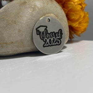 Clase de 2025 con birrete de graduación en dije redondo de acero ...