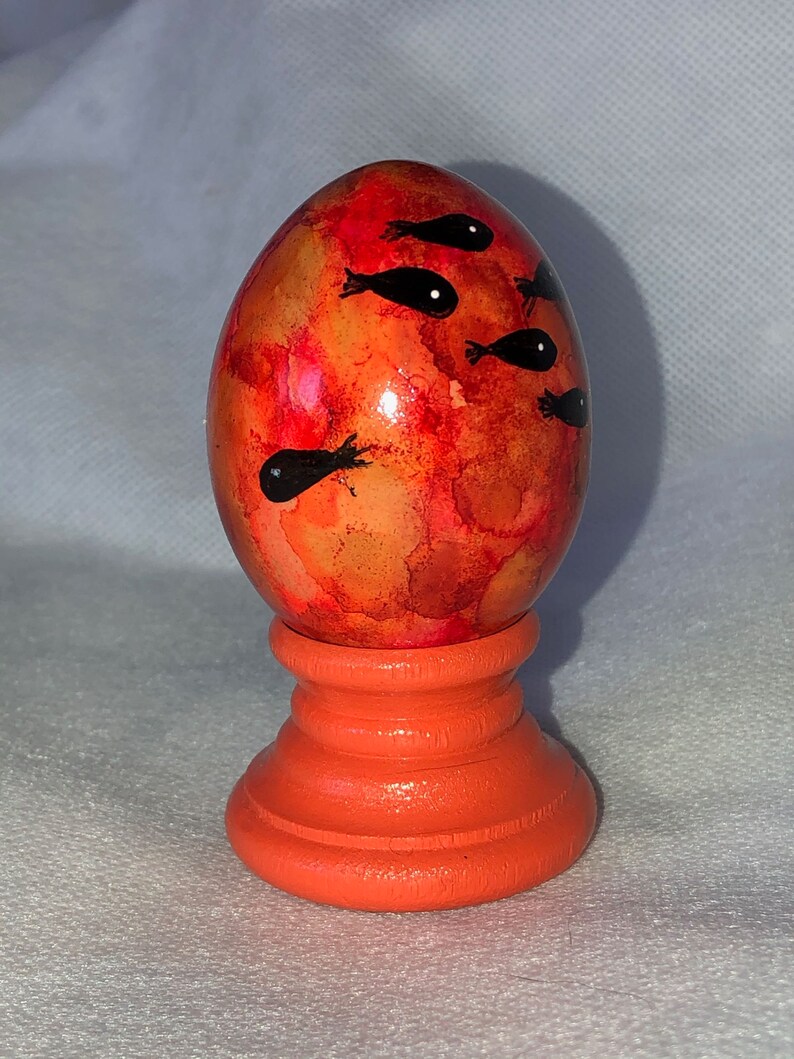 Orange Alcohol Ink Chicken Egg With School of Little Black Fish With ...