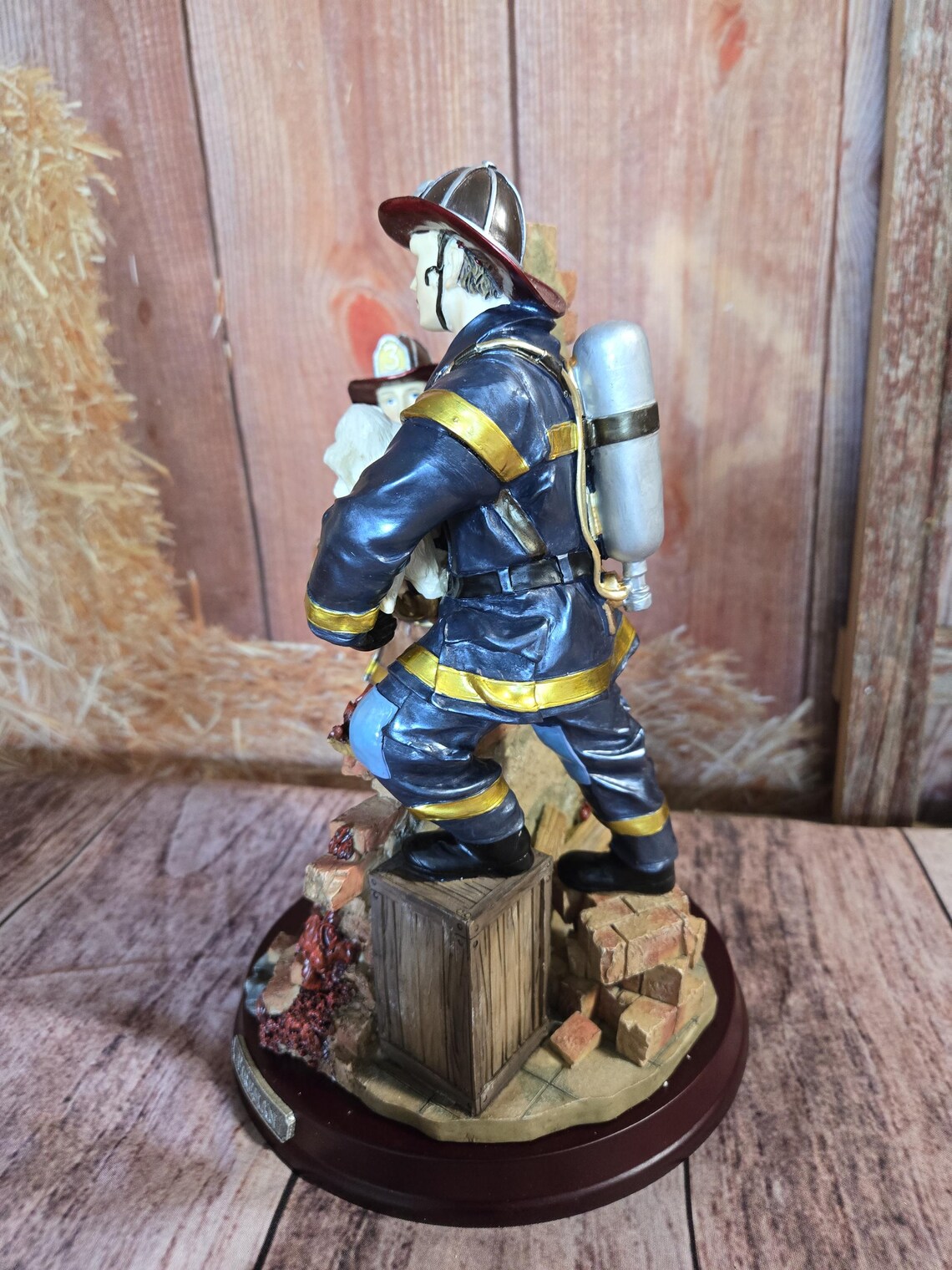 Statue of a Firefighter Handing a Puppy Out of a Burning Building to ...
