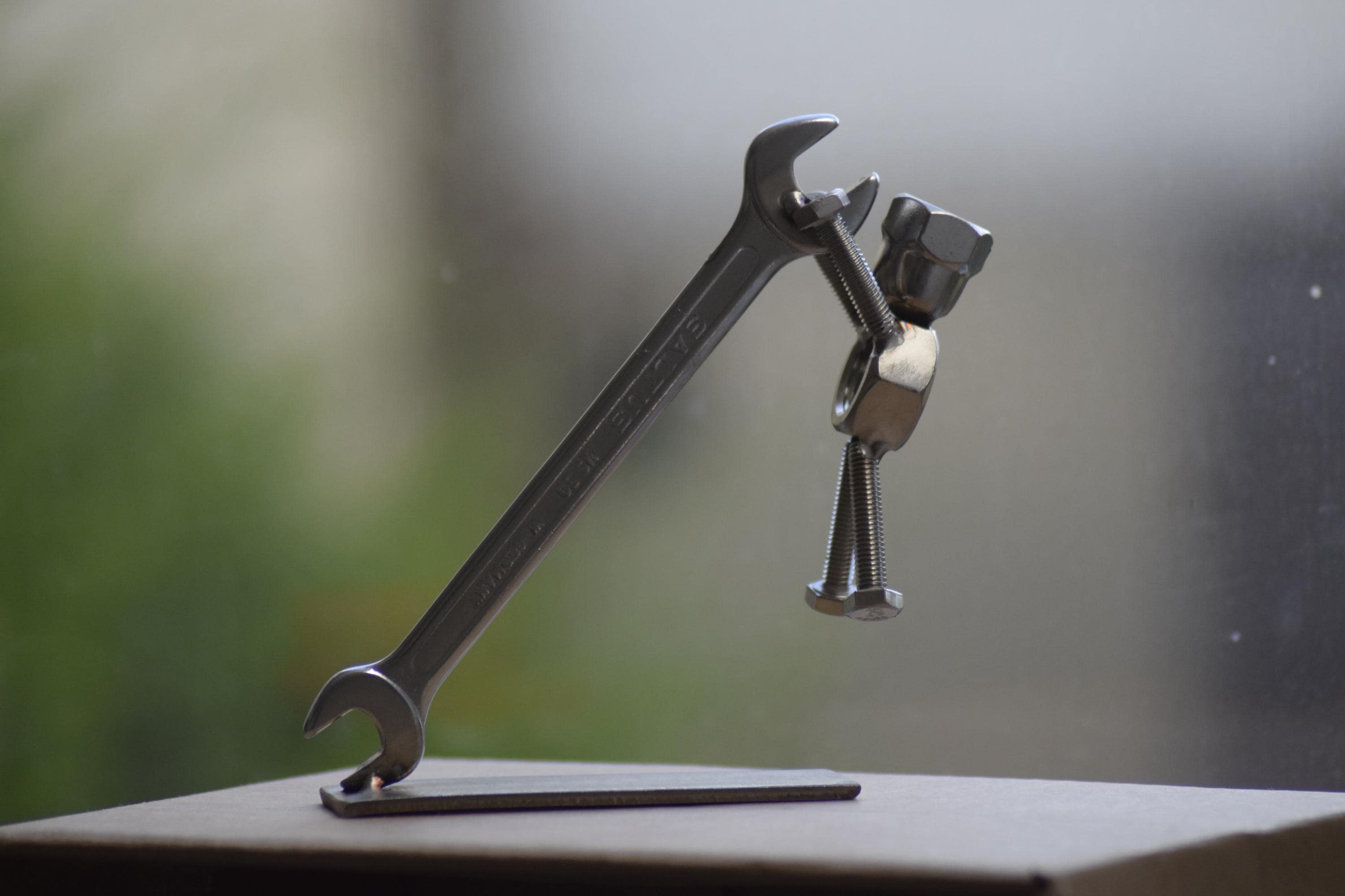 Metal Sculpture of Mechanic Hanging From A Spanner - Nuts and Bolts ...