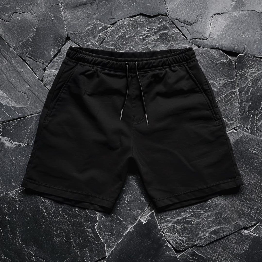 Mockup of Men’s Black Cotton Shorts Laying Flat on a Black Stone ...