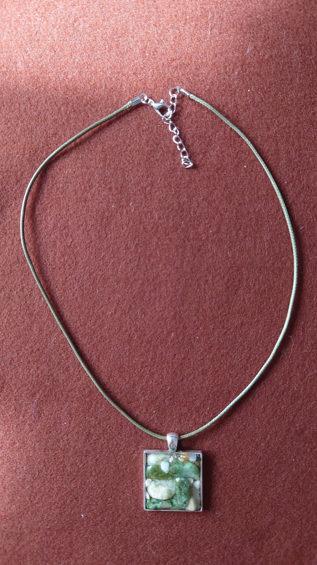 A Square Silver Coloured Pendant Encrusted With Polished Agate, Sealed ...