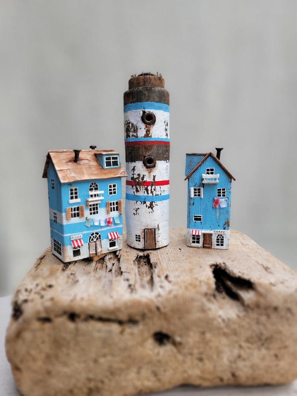 Miniature Houses and a Driftwood Lighthouse Overlooking the Ocean ...