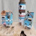 Miniature Houses and a Driftwood Lighthouse Overlooking the Ocean ...