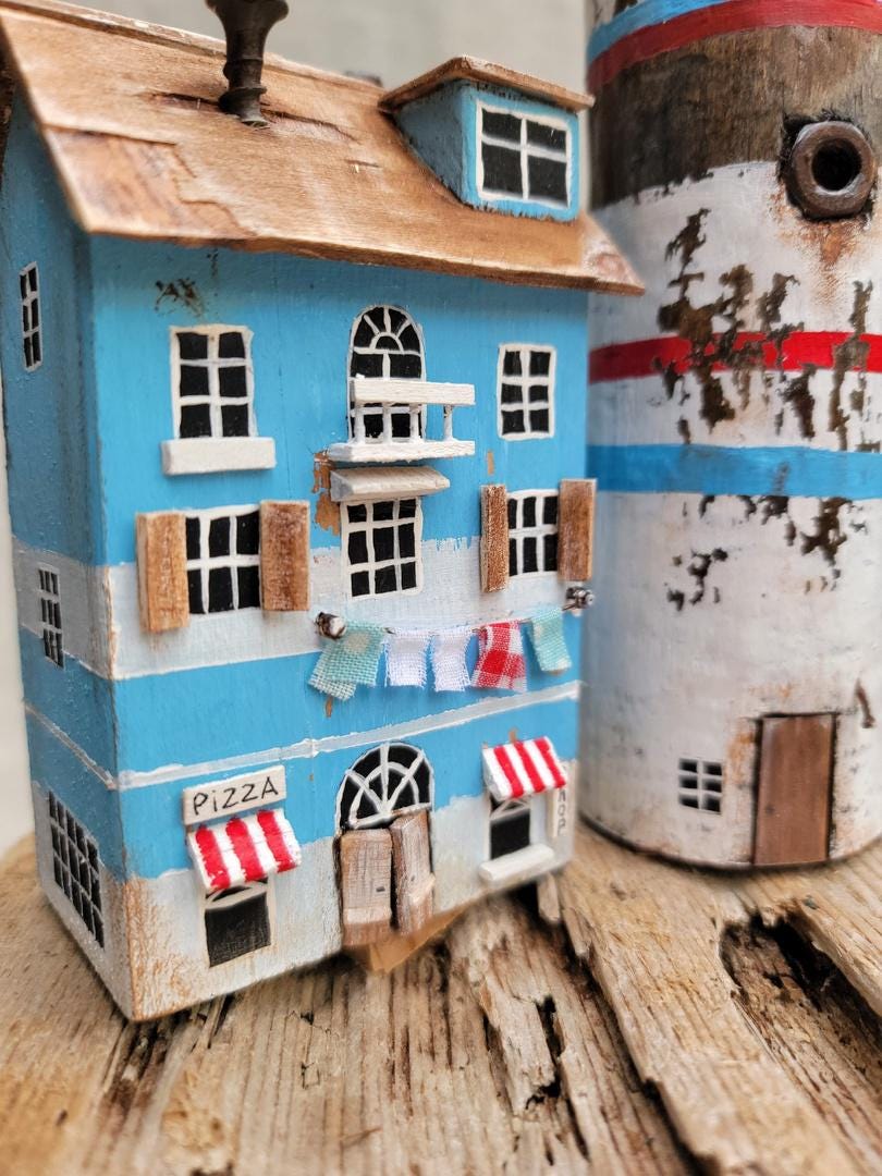 Miniature Houses and a Driftwood Lighthouse Overlooking the Ocean ...