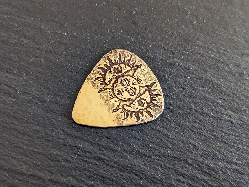 Brass Guitar Pick With a Three Face Sun and a Hammered Sparkly Texture ...